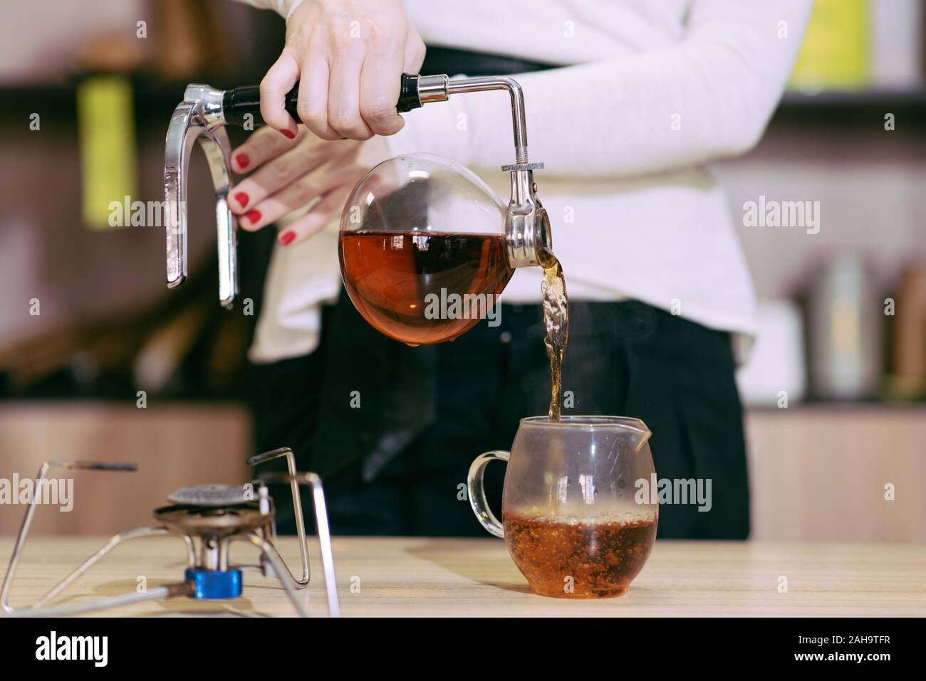 A girl is making tea in a siphon Stock Photo - Alamy