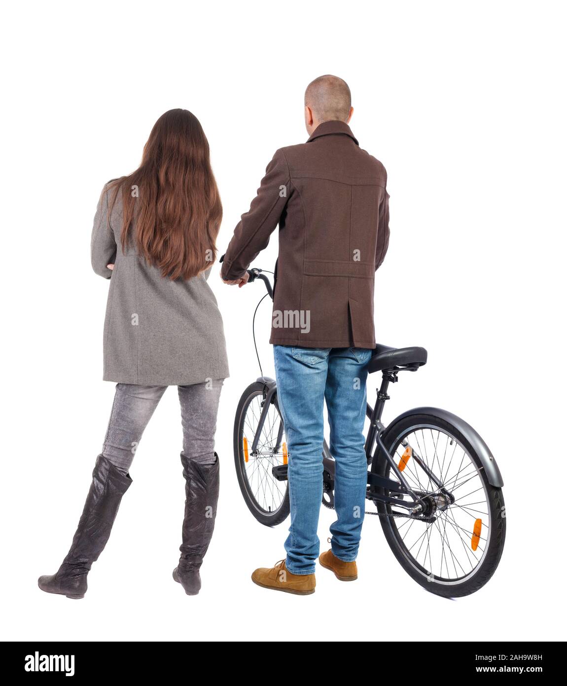 Back view of couple in winter jacket. man on a bicycle and a woman ...
