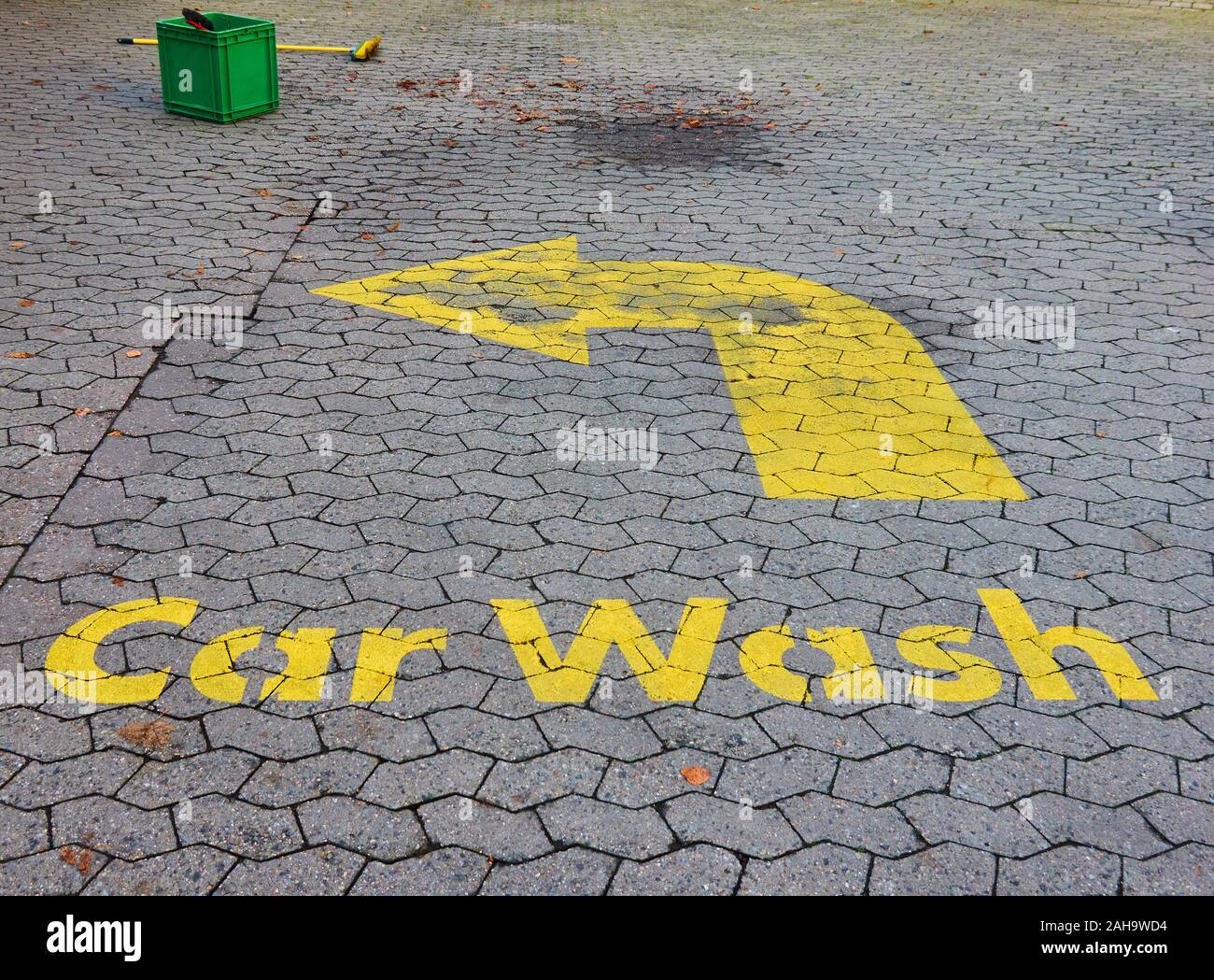 Washed-out old ugly painted yellow entry sign for a car wash on a dirty ...