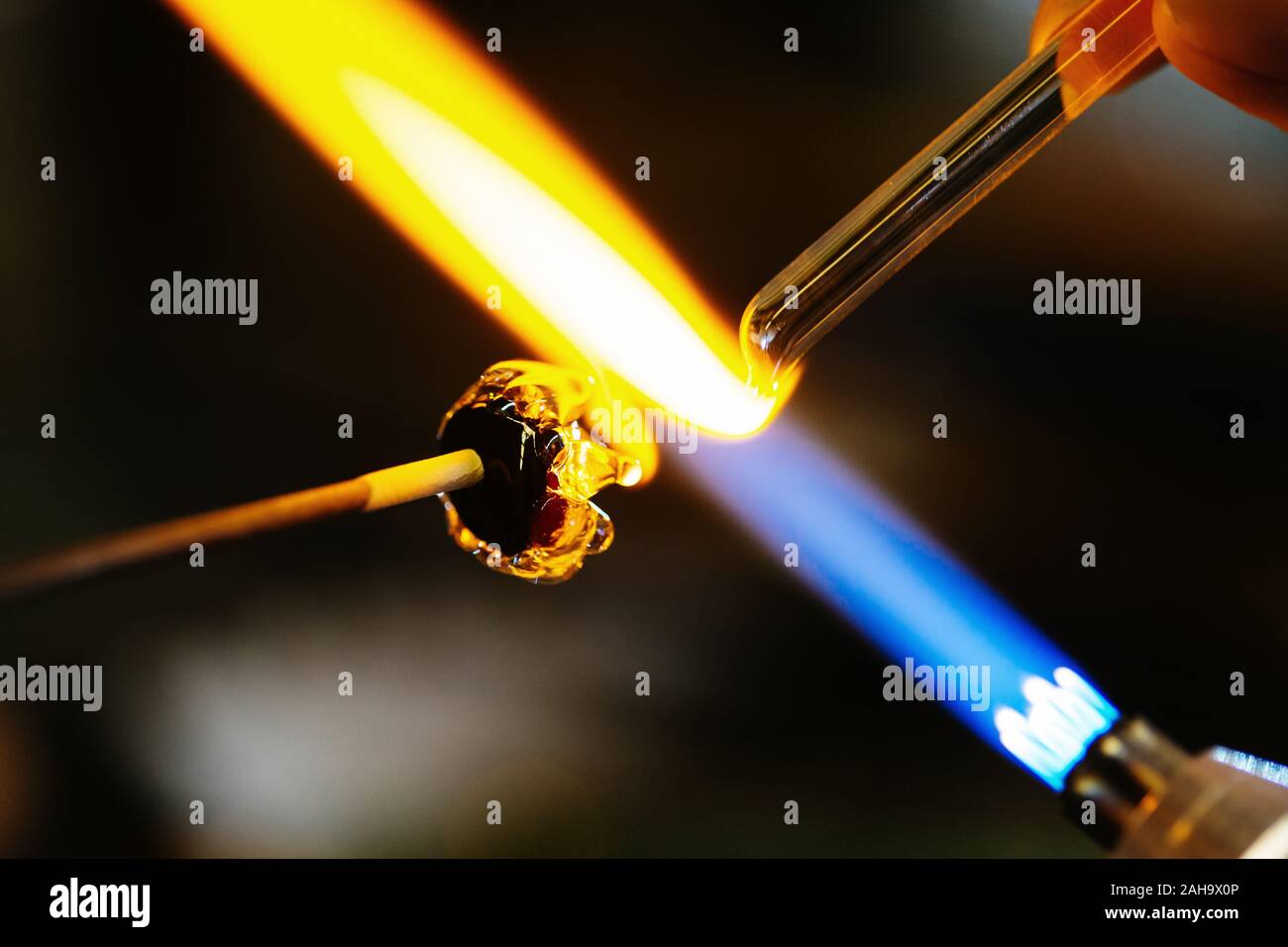 Close-up of glass bead melting in gas-burner fire, craftwork Stock ...