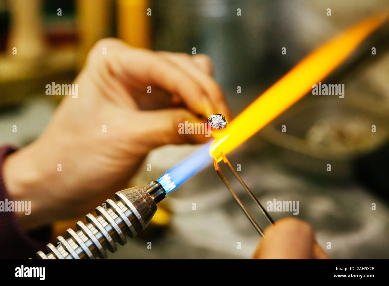 Close-up of glass bead melting in gas-burner fire, craftwork Stock ...