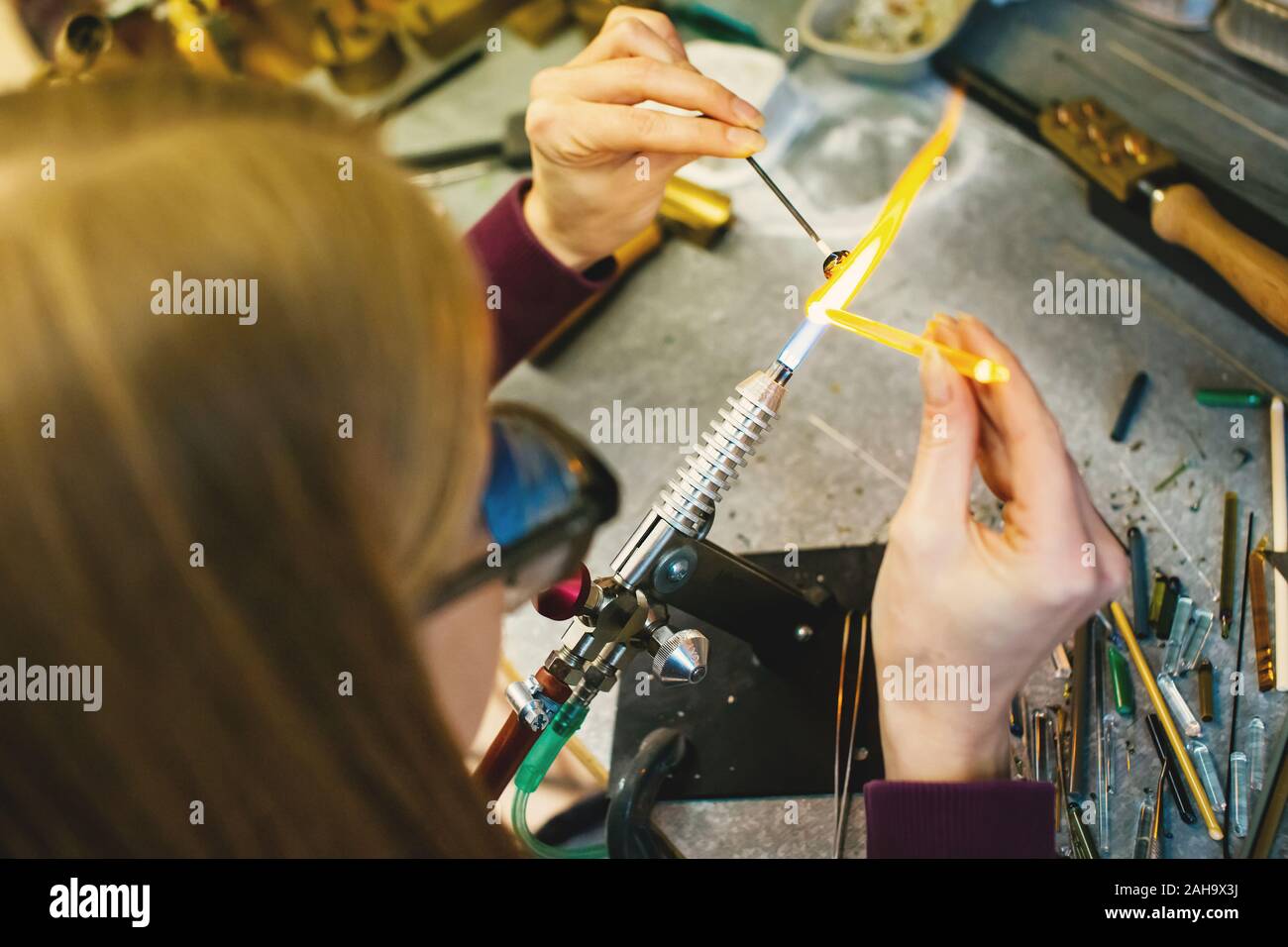 Artist in workshop making glass bead in gas-burner fire Stock Photo - Alamy