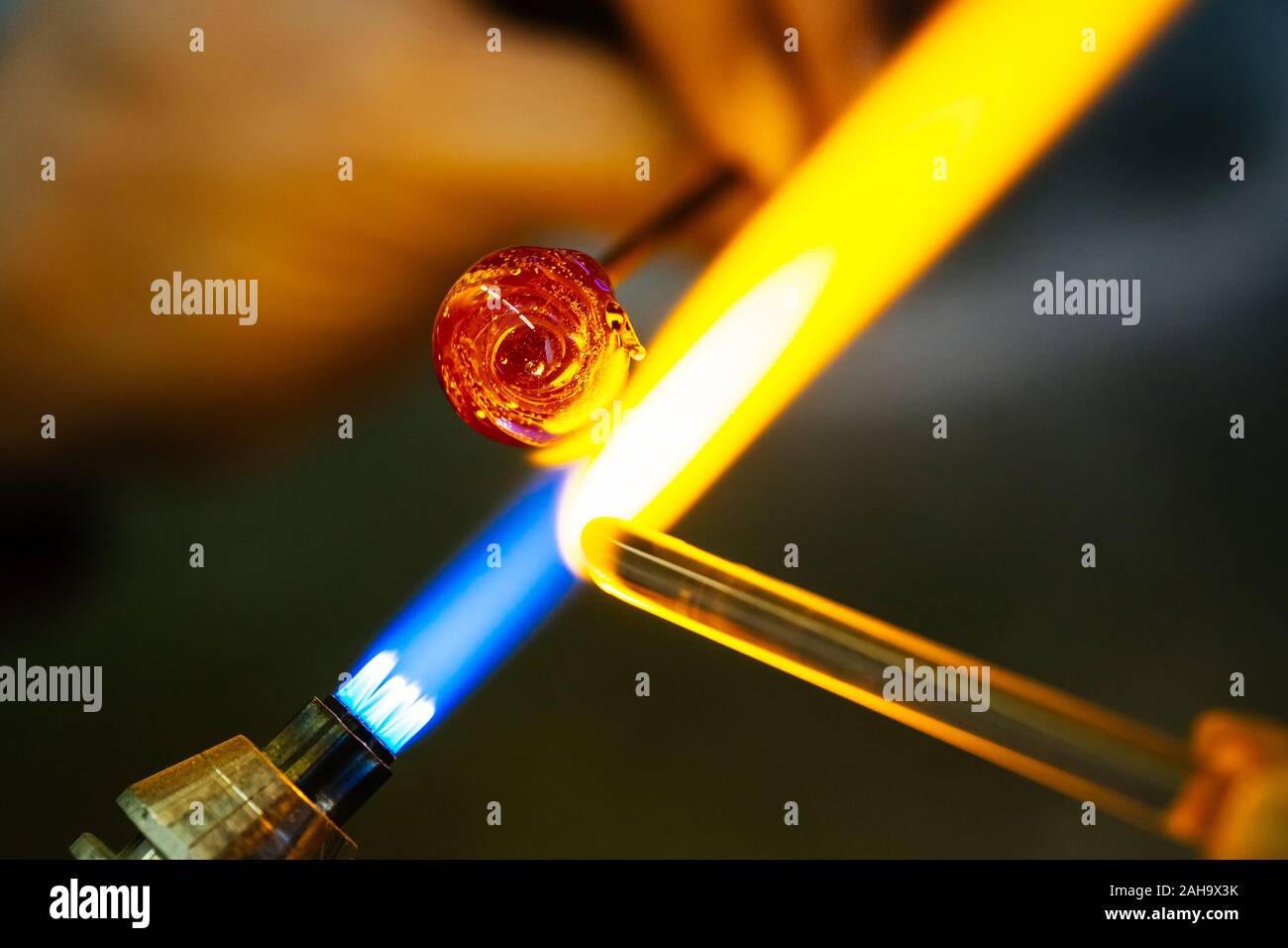 Close-up of glass bead melting in gas-burner fire, craftwork Stock ...