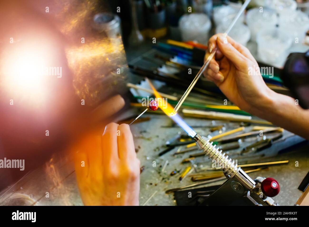 Close-up of glass bead melting in gas-burner fire, craftwork Stock ...
