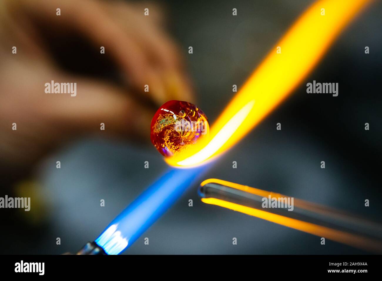 Close-up of glass bead melting in gas-burner fire, craftwork Stock ...