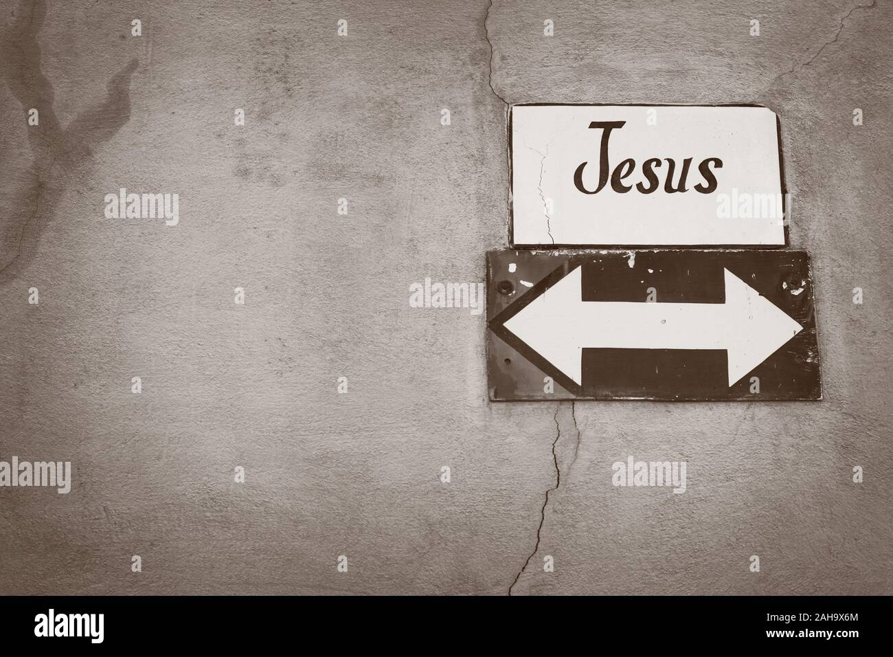 Jesus road sign arrow on a cracked concrete wall. Concept for doubt in ...