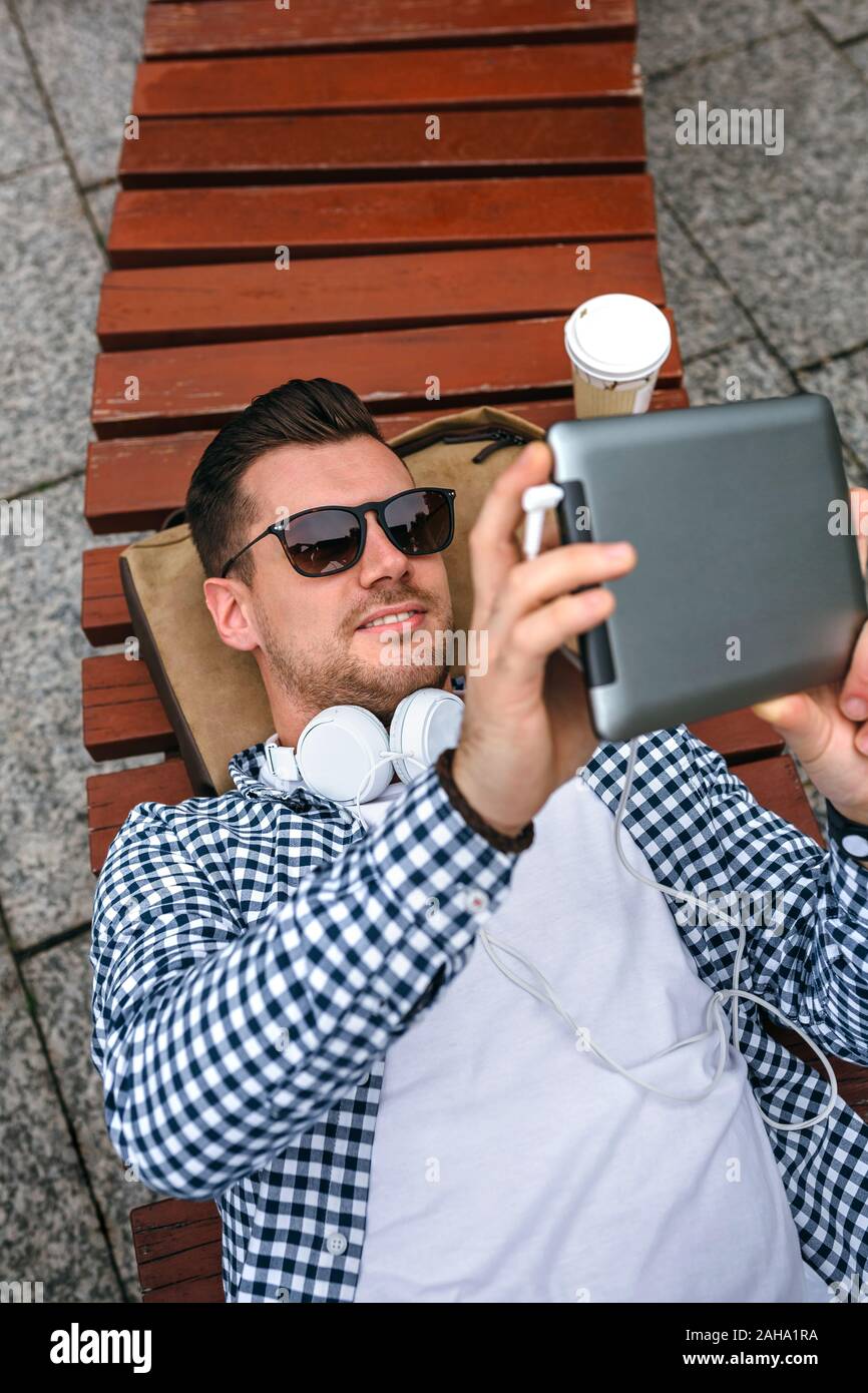 Young man using tablet outdoors Stock Photo - Alamy