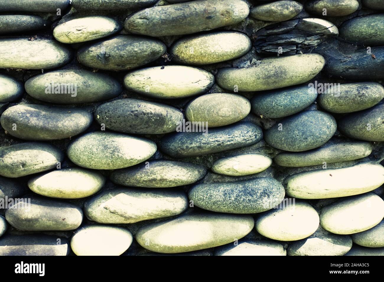 Stone wall of pebbles with concrete in garden background Stock Photo ...