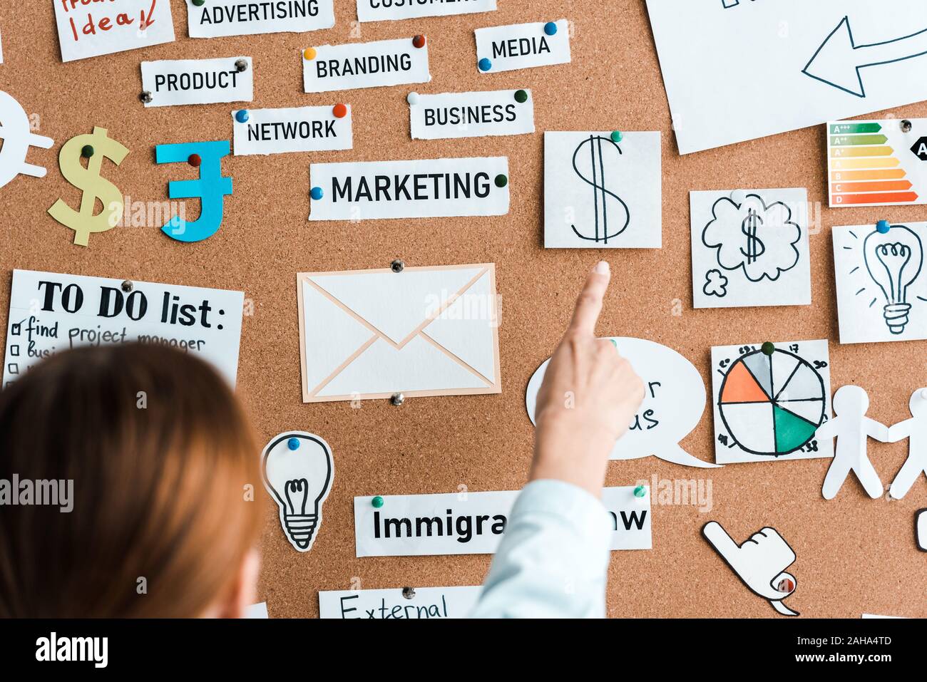 cropped view of businesswoman pointing with finger at sticky notes on ...