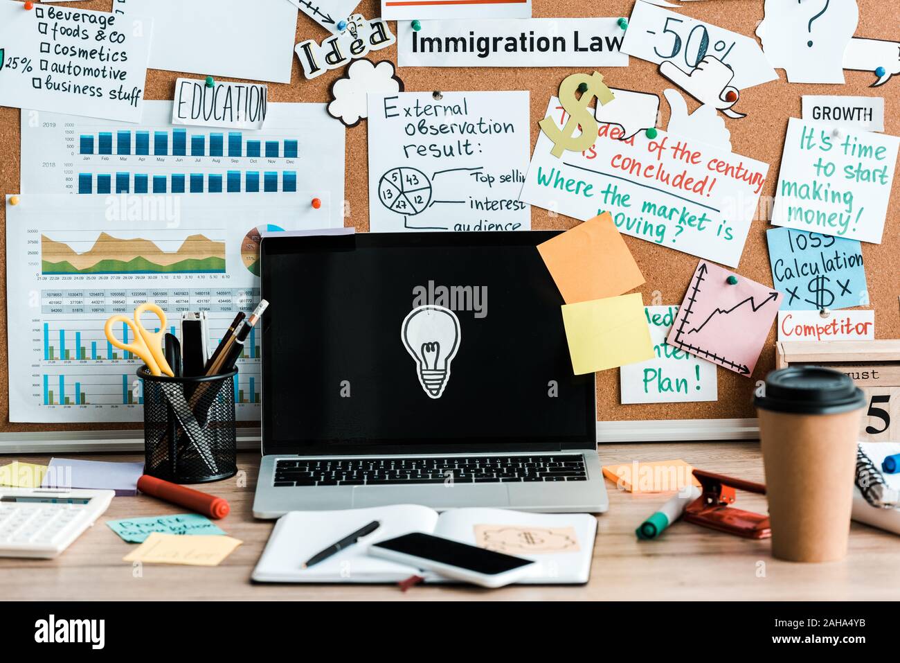 laptop and smartphone on desk near sticky notes with lettering on ...