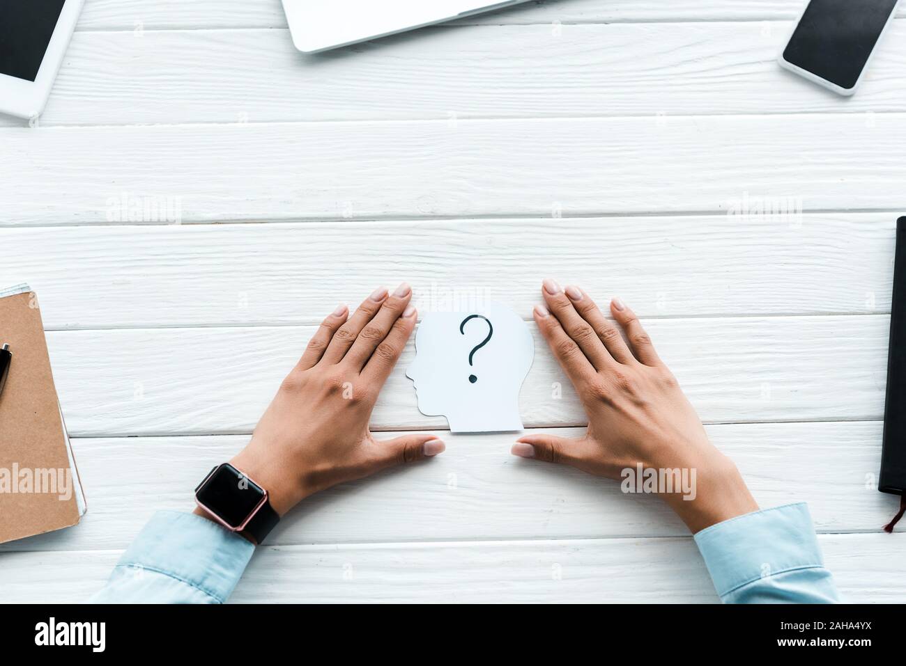 top view of woman touching paper with question mark near gadgets on ...
