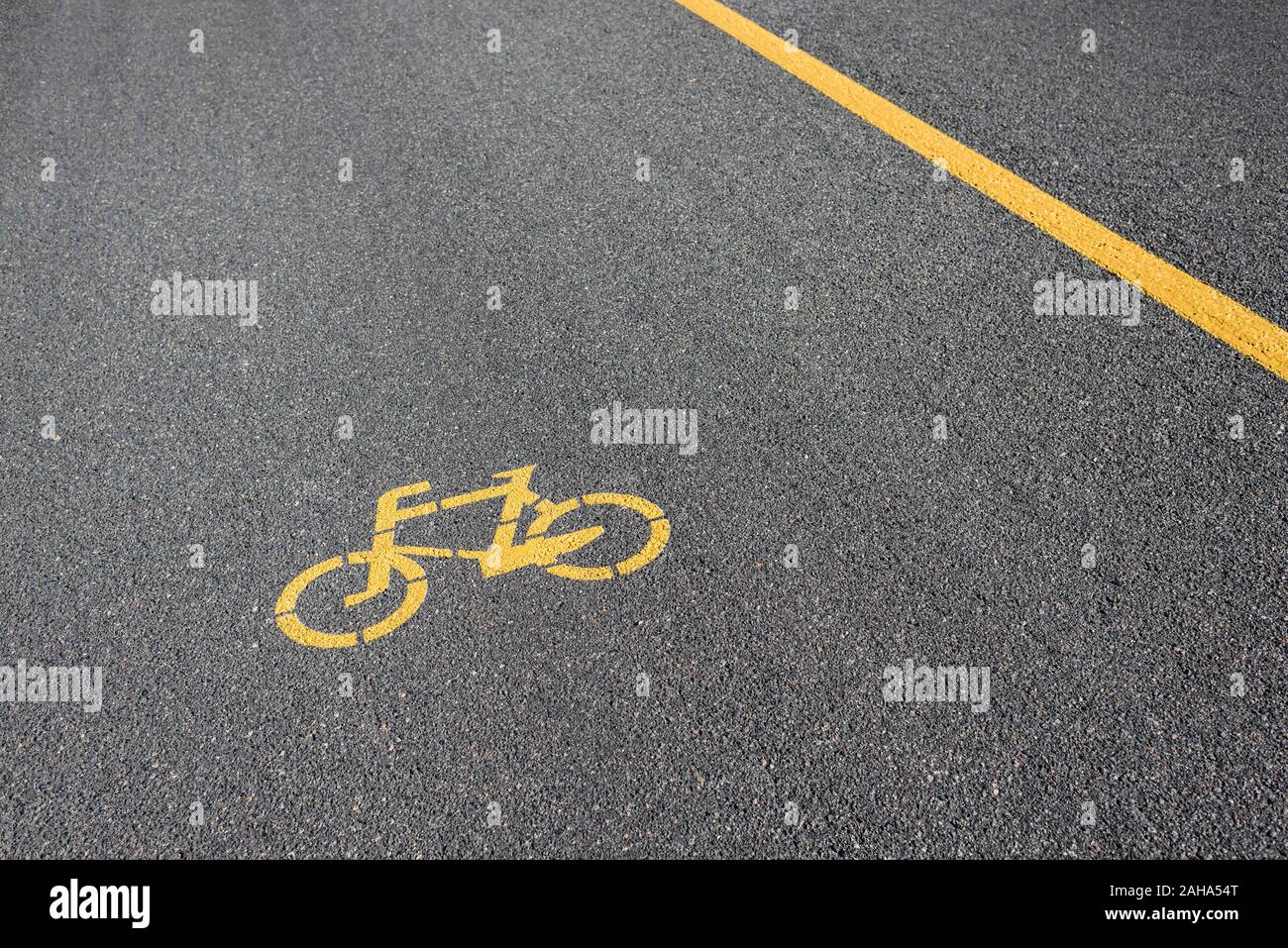 yellow symbol of bicycle path on grey asphalt Stock Photo - Alamy