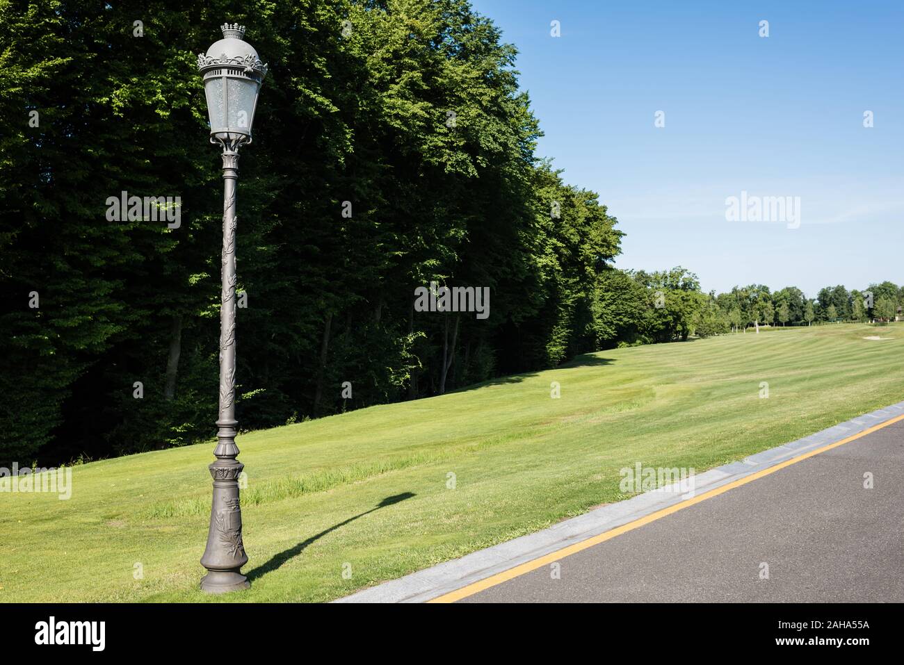 street lamp on green fresh grass near trees and blue sky Stock Photo ...