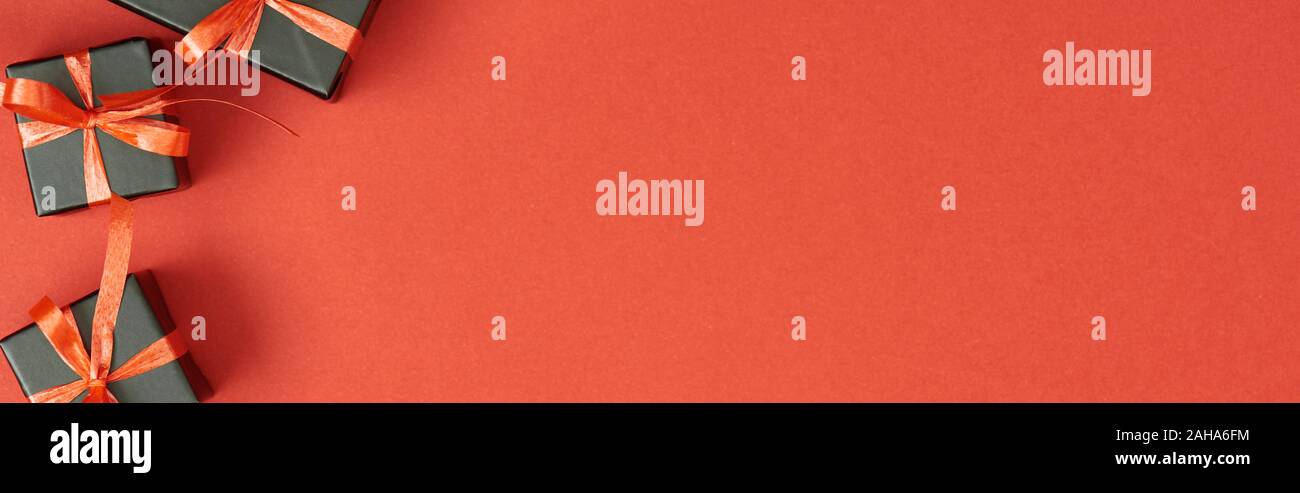 top view of black small gift boxes on red background with copy space ...