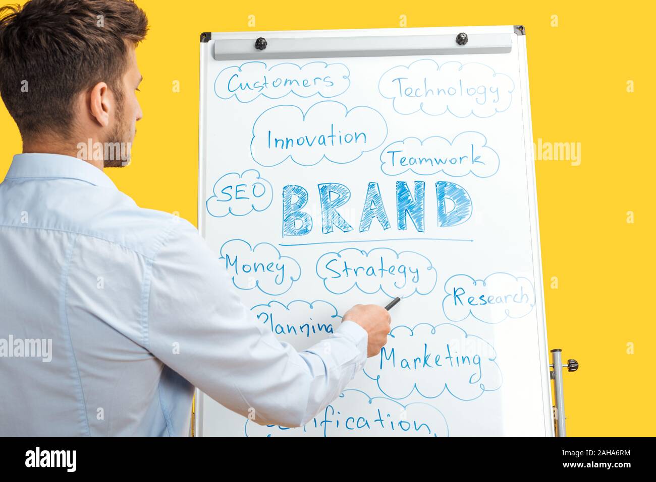 back view of businessman standing near white office board, pointing at ...