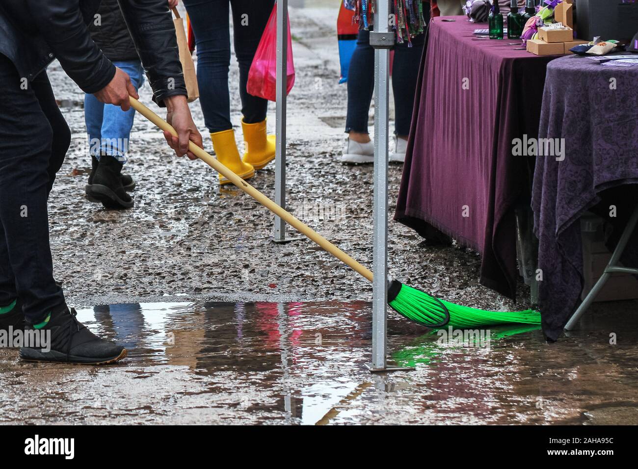 Man with broom on street market after rain Stock Photo - Alamy