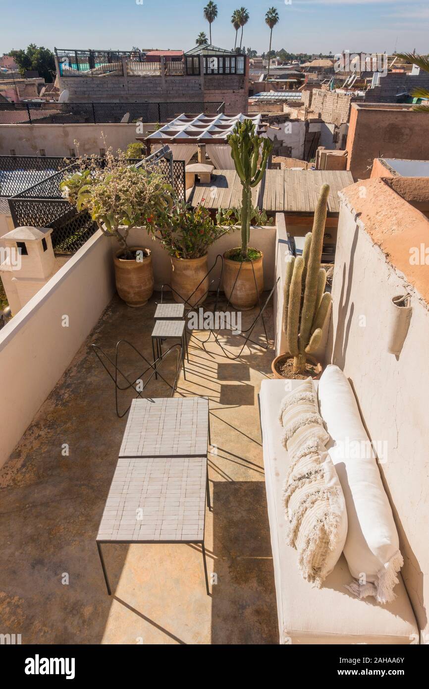 Rooftop terrace with chairs at a Riad, Marrakech city skyline in Medina ...