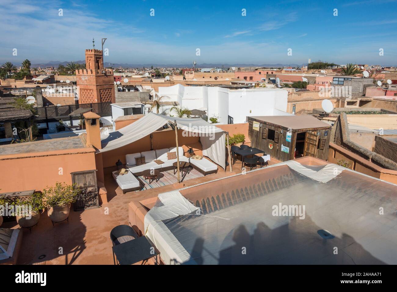 Rooftop terrace with chairs at a Riad, Marrakech city skyline in Medina ...