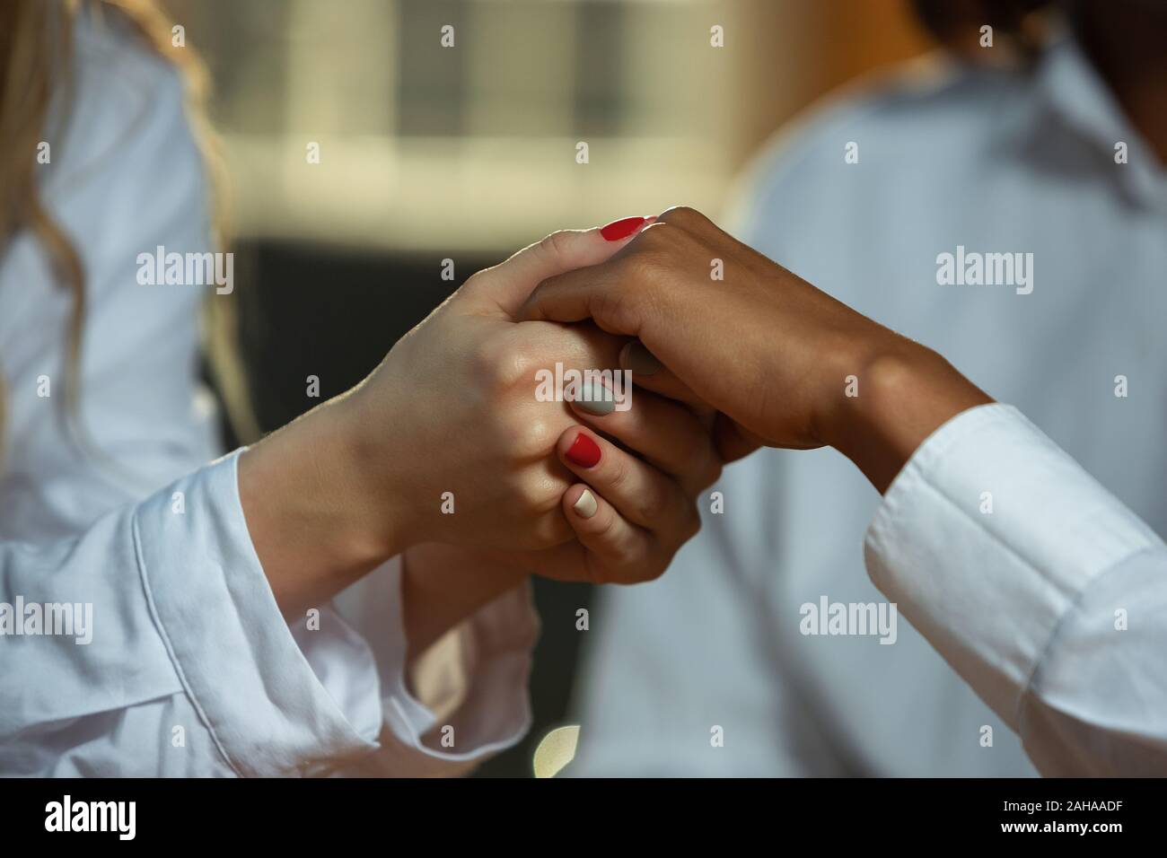 Close up of african-american and caucasian human's hands holding on ...