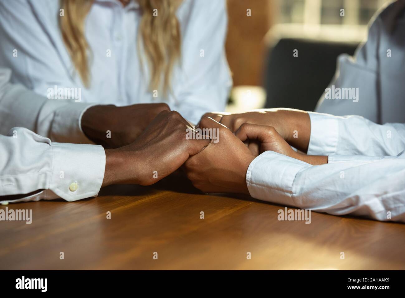Close up of african-american and caucasian human's hands holding on ...
