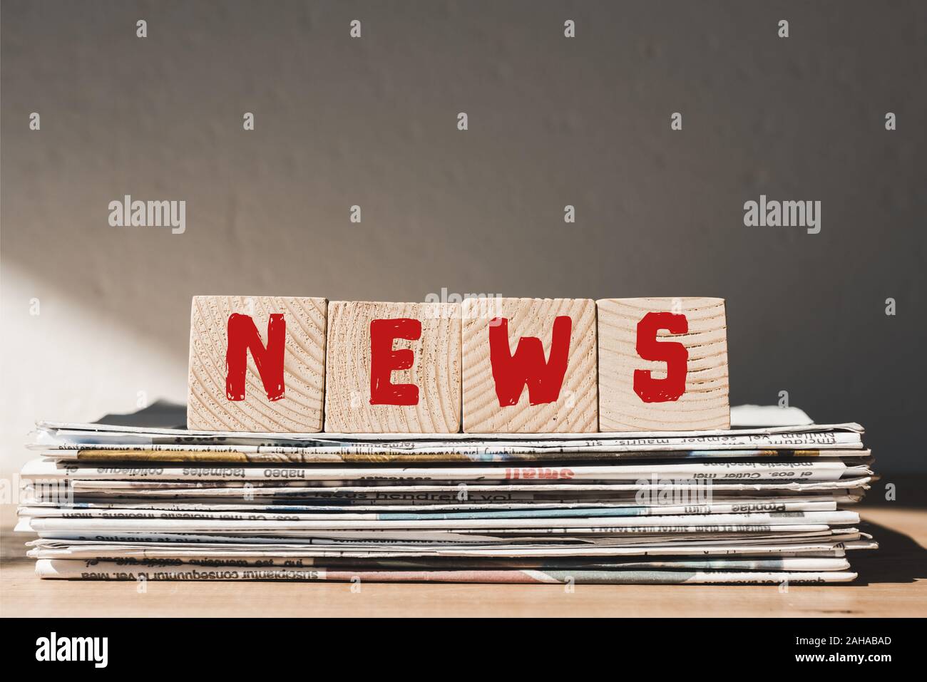 wooden blocks with red news lettering on pile of newspapers Stock Photo ...