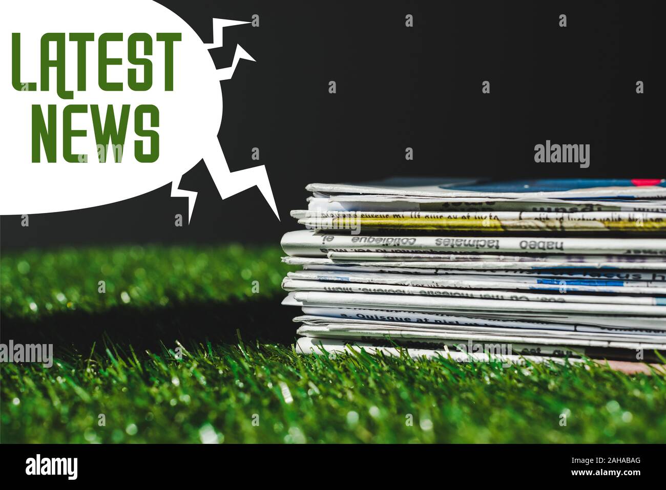 stack of different print newspapers on fresh green grass near speech ...