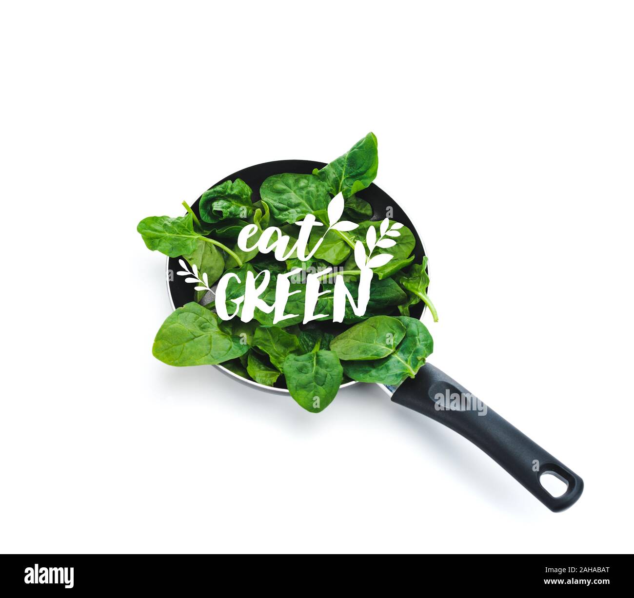 fresh spinach leaves in frying pan with eat green lettering on white ...