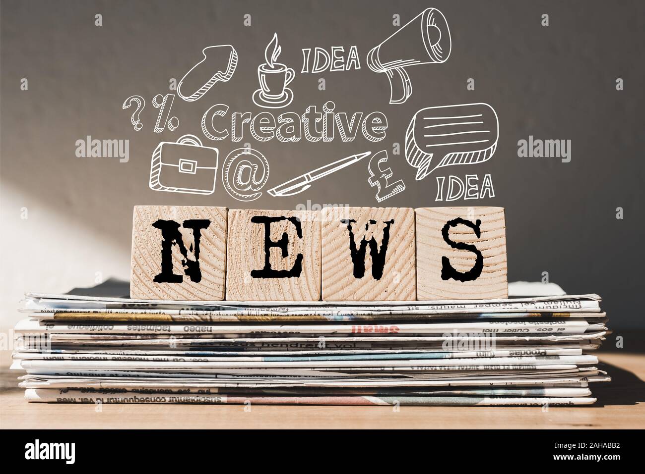 wooden blocks with black news lettering on pile of newspapers with idea ...
