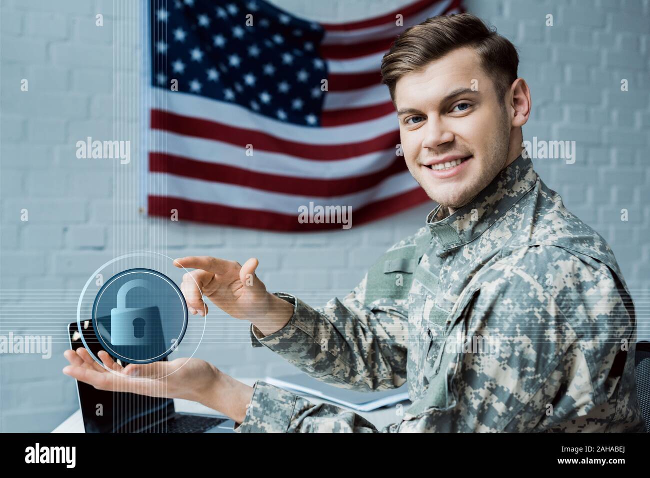 happy military man gesturing in office near virtual padlock and laptop ...