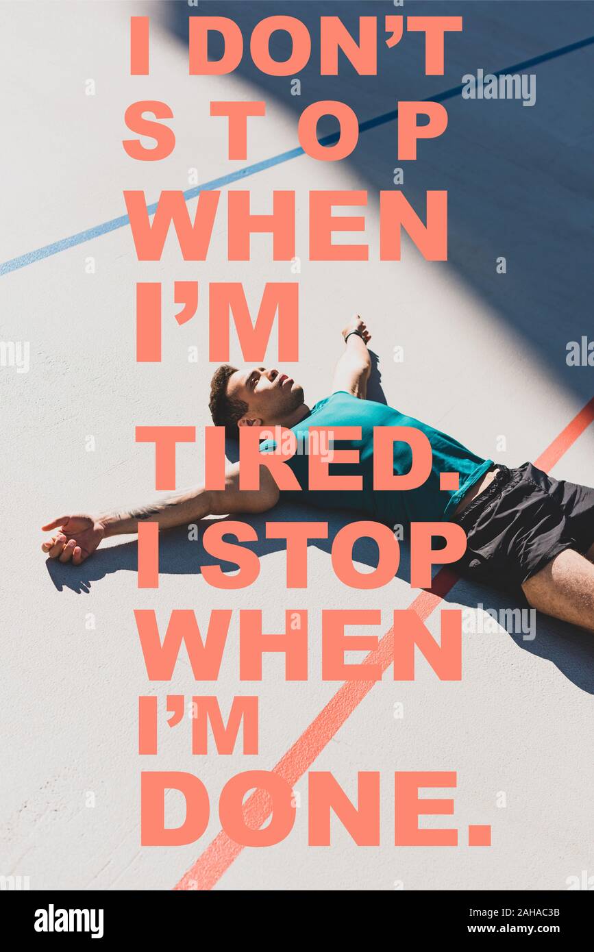 mixed race sportsman laying on running track and spread arms with i ...