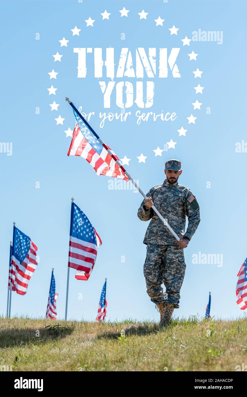 handsome soldier in military uniform and cap holding american flag with ...