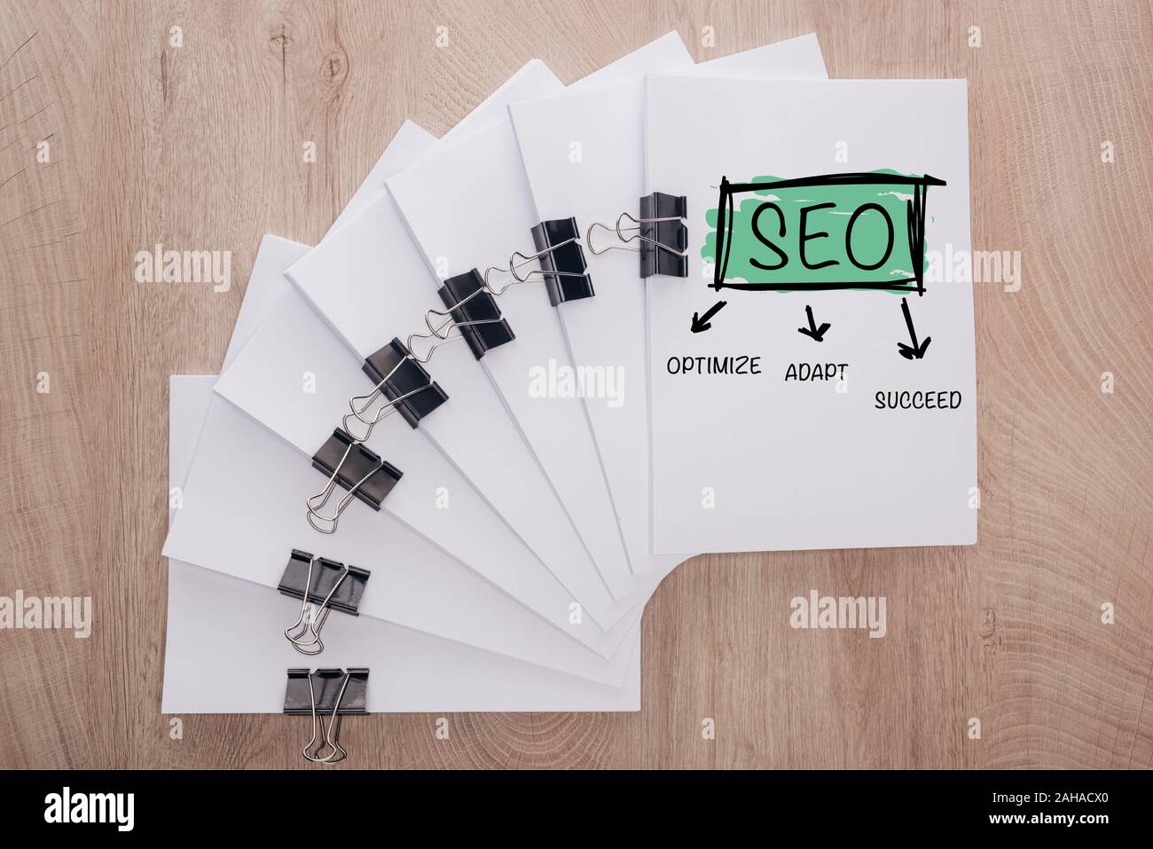 top view of white paper sheets arranged with binder clips and seo ...
