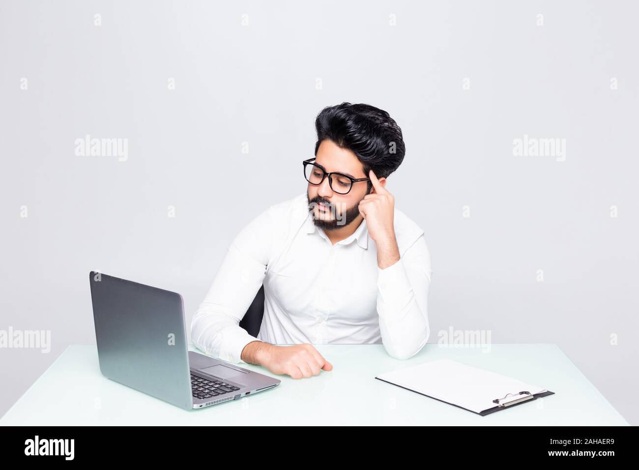 Young man concentrating on computer work, looking at laptop screen ...