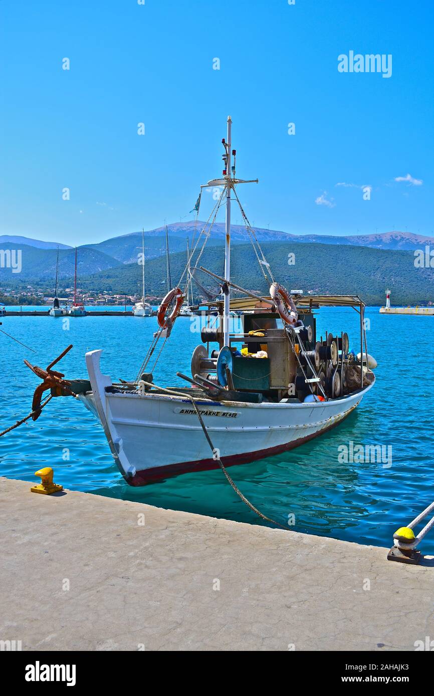 A traditional Greek fishing boat moored in the harbour of the beautiful ...