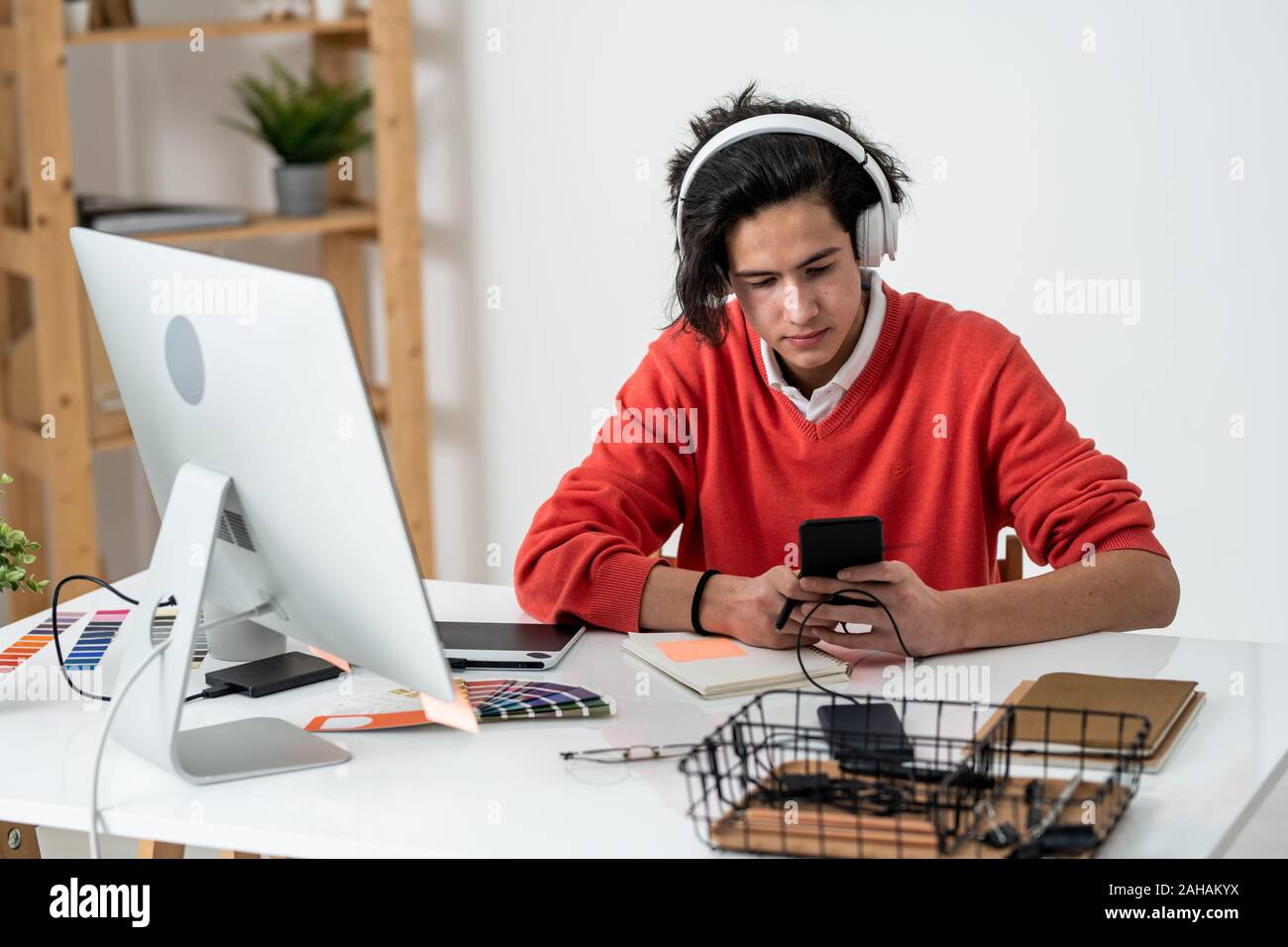 Serious guy scrolling in smartphone while listening to music during ...