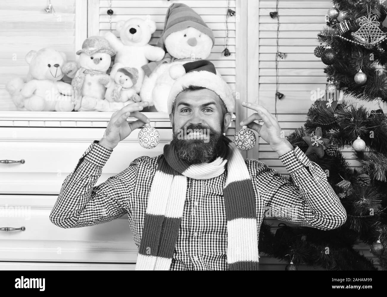 Santa Claus with happy face near wooden wall, bureau and Christmas tree ...