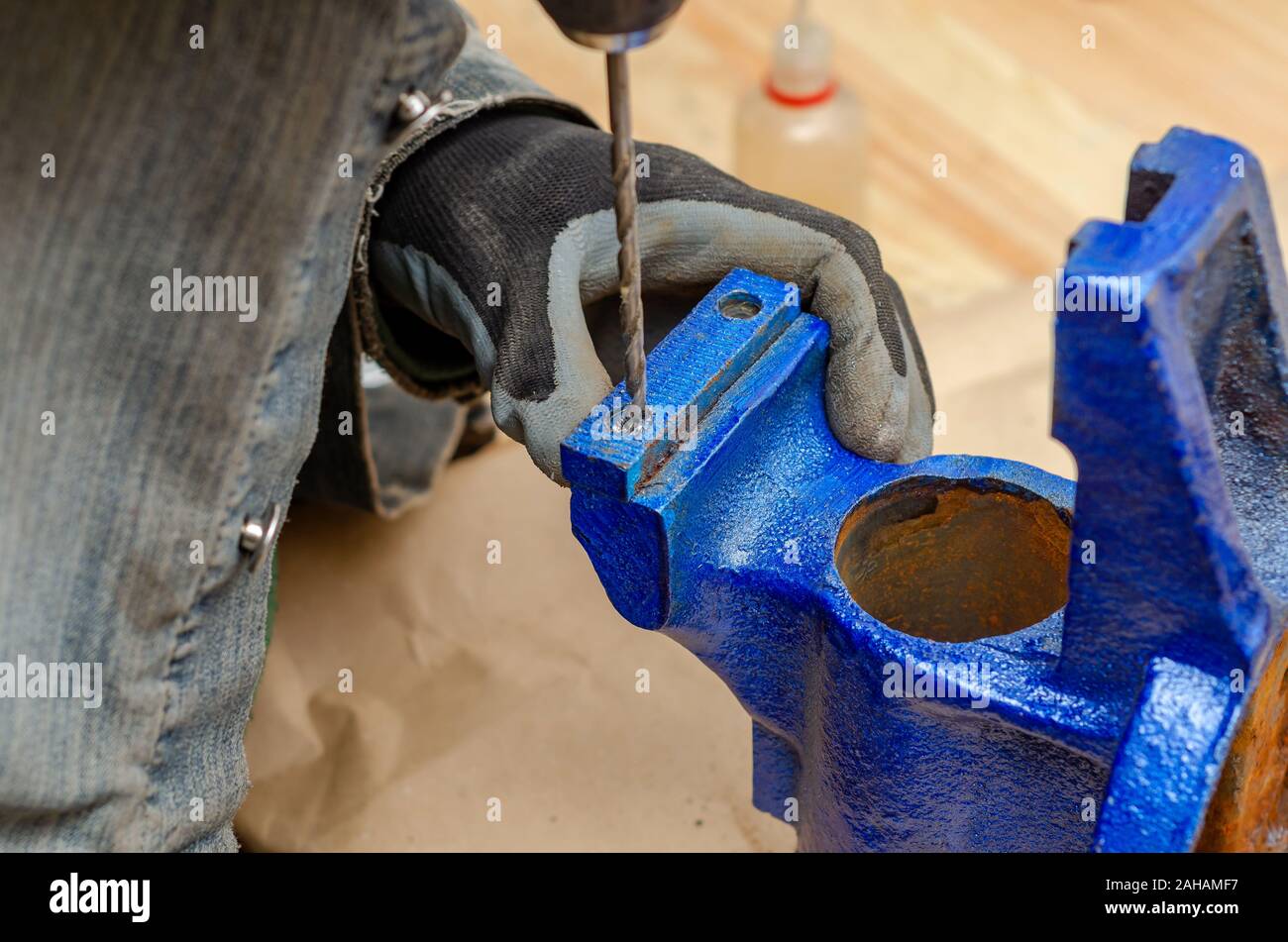 Worker man dismantles old metal vice in workshop Stock Photo - Alamy