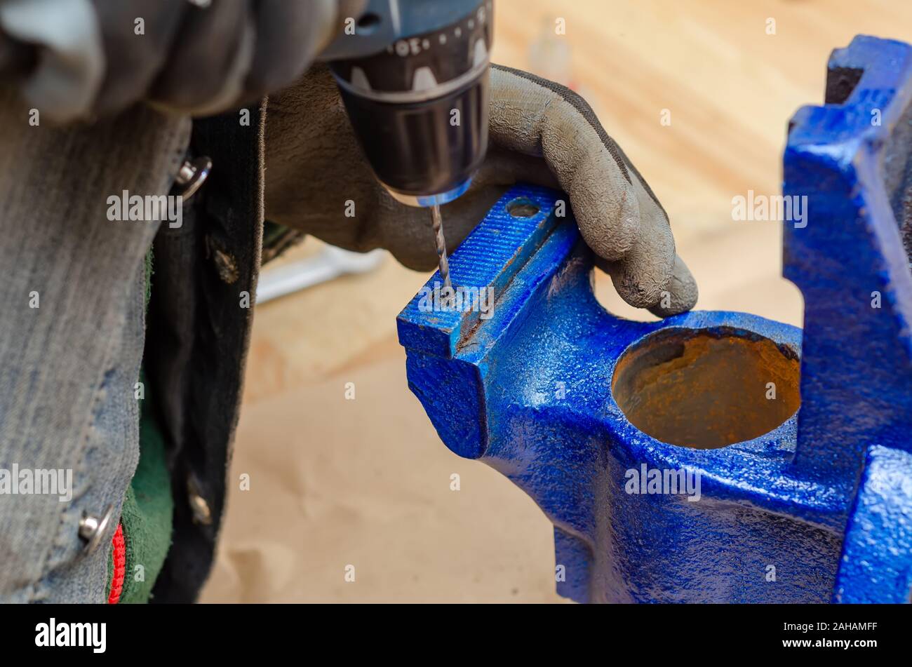Worker man dismantles old metal vice in workshop Stock Photo - Alamy