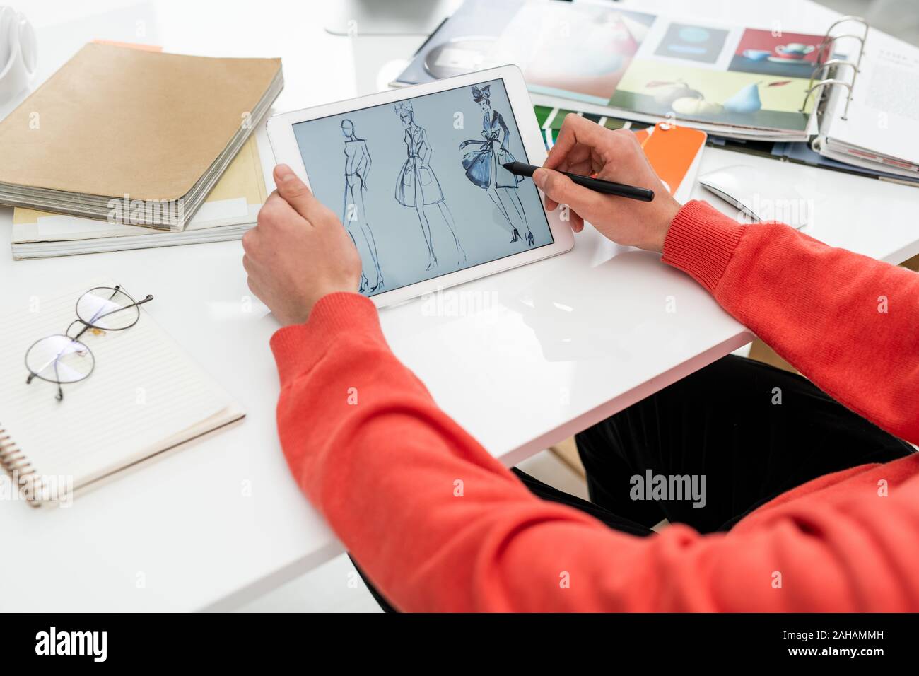 Hands of creative fashion designer with stylus pointing at one of new ...