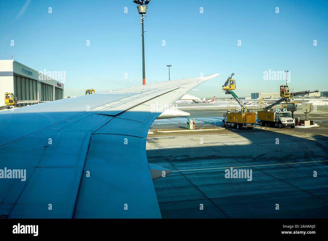Boeing 737 wing worker is de-icing a commercial airliner wing in ...