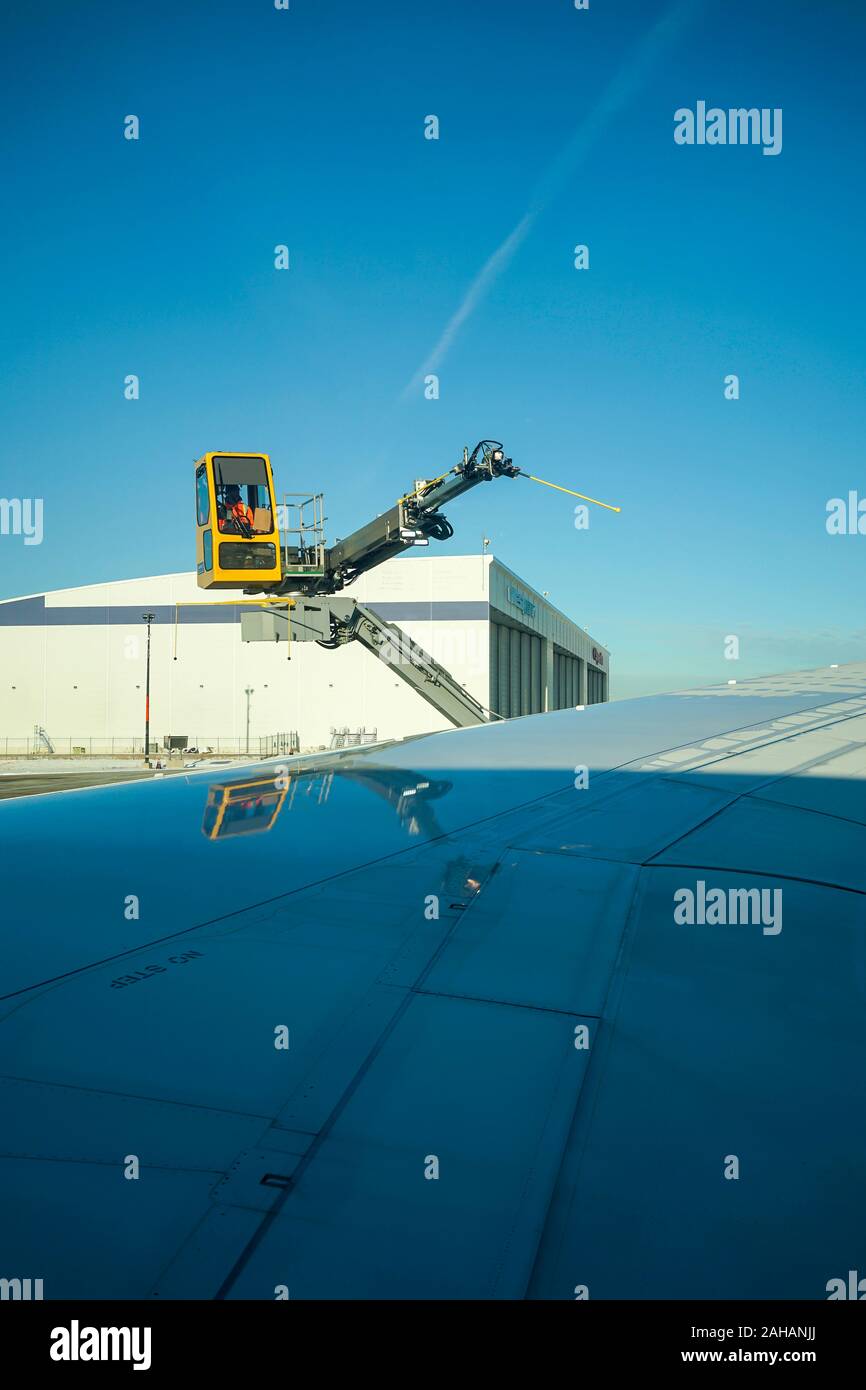 Boeing 737 wing worker is de-icing a commercial airliner wing in ...