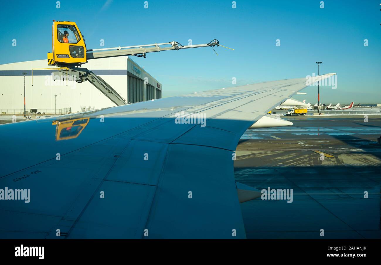 Boeing 737 wing worker is de-icing a commercial airliner wing in ...