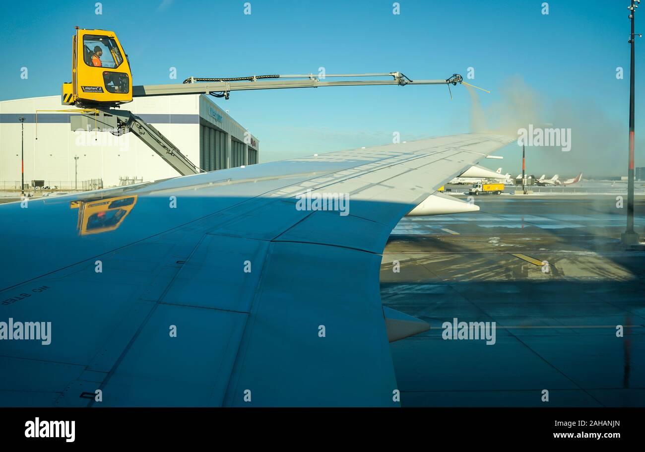 Boeing 737 wing worker is de-icing a commercial airliner wing in ...