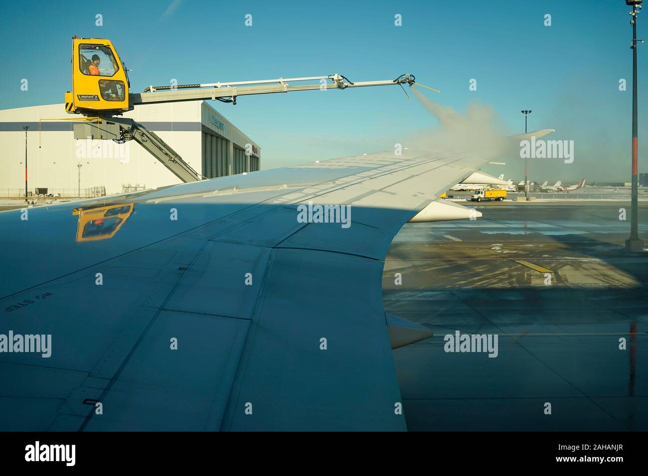 Boeing 737 wing worker is de-icing a commercial airliner wing in ...