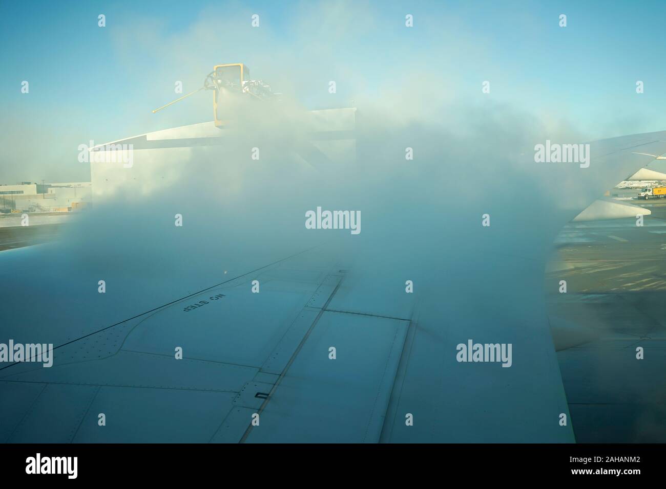 Boeing 737 wing worker is de-icing a commercial airliner wing in ...