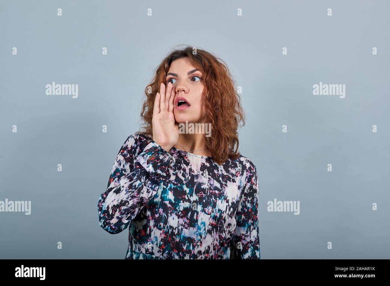 Shocked caucasian young woman keeping hand on face, scream, announcing ...