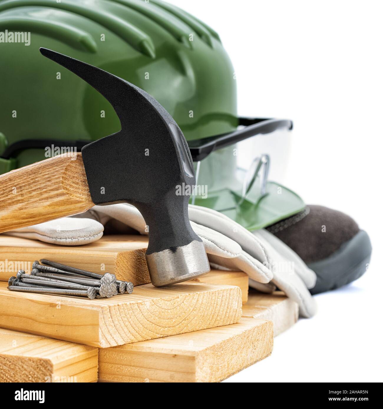 Close-up of a carpenter's hammer, helmet, goggles and protective gloves ...