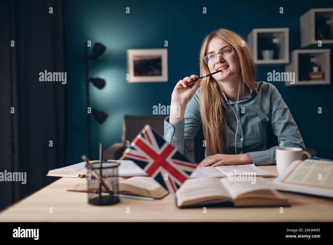 Cheerful ginger student girl in glasses thinking touching her lip with ...