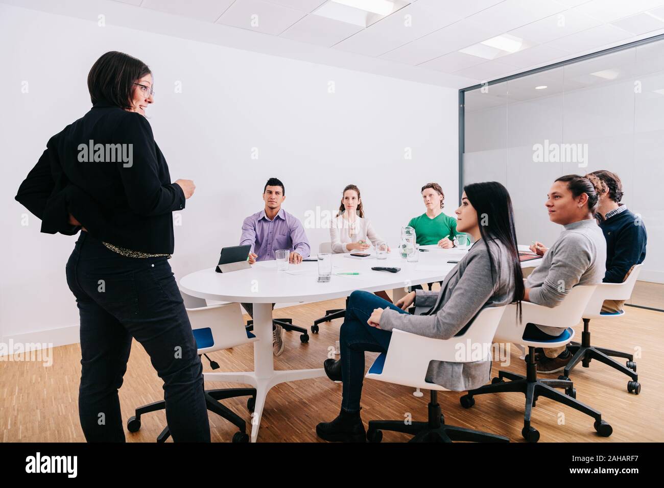 Group of office workers at a meeting around the boss Stock Photo - Alamy