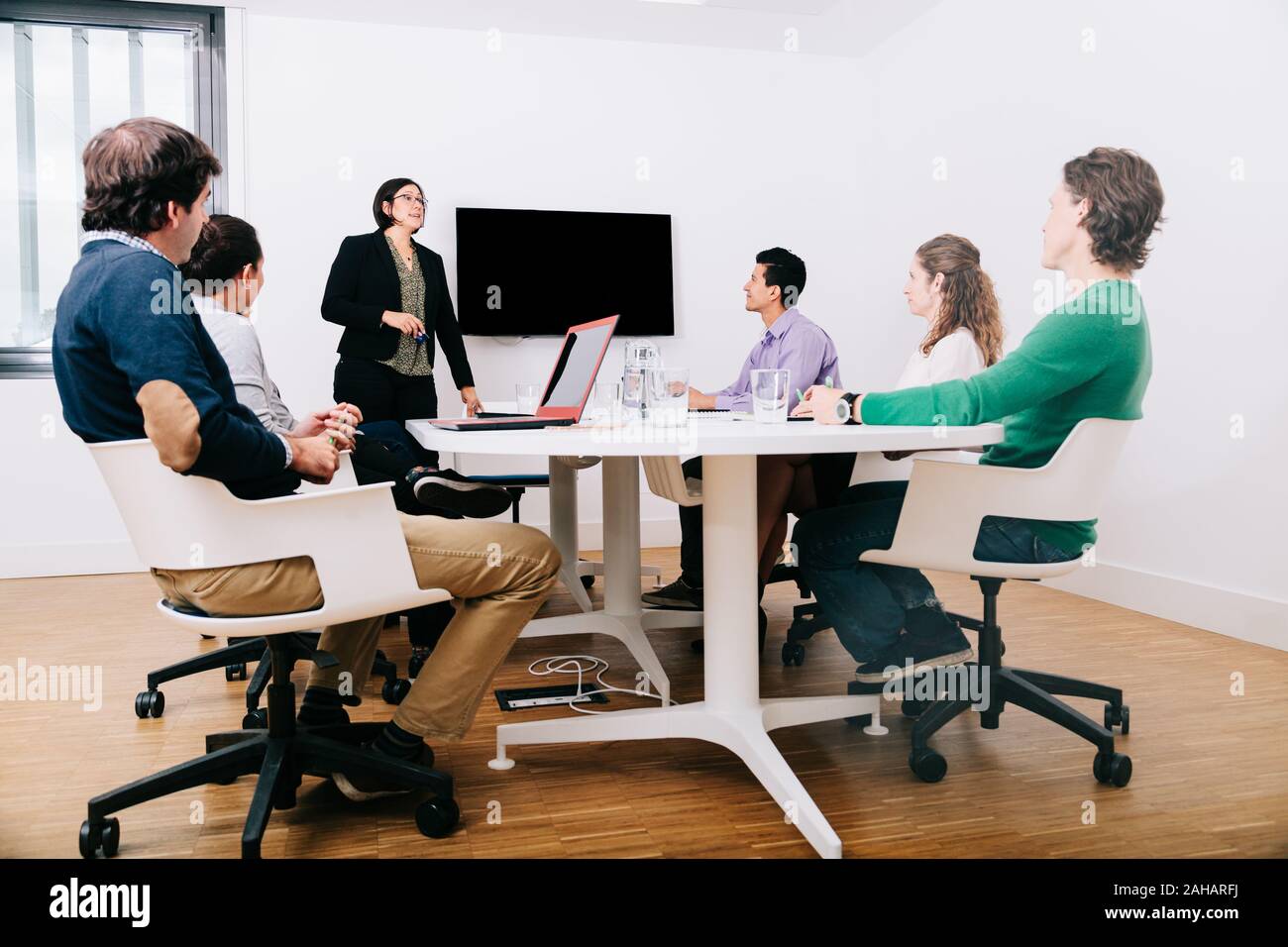 Group of office workers at a meeting around the boss Stock Photo - Alamy